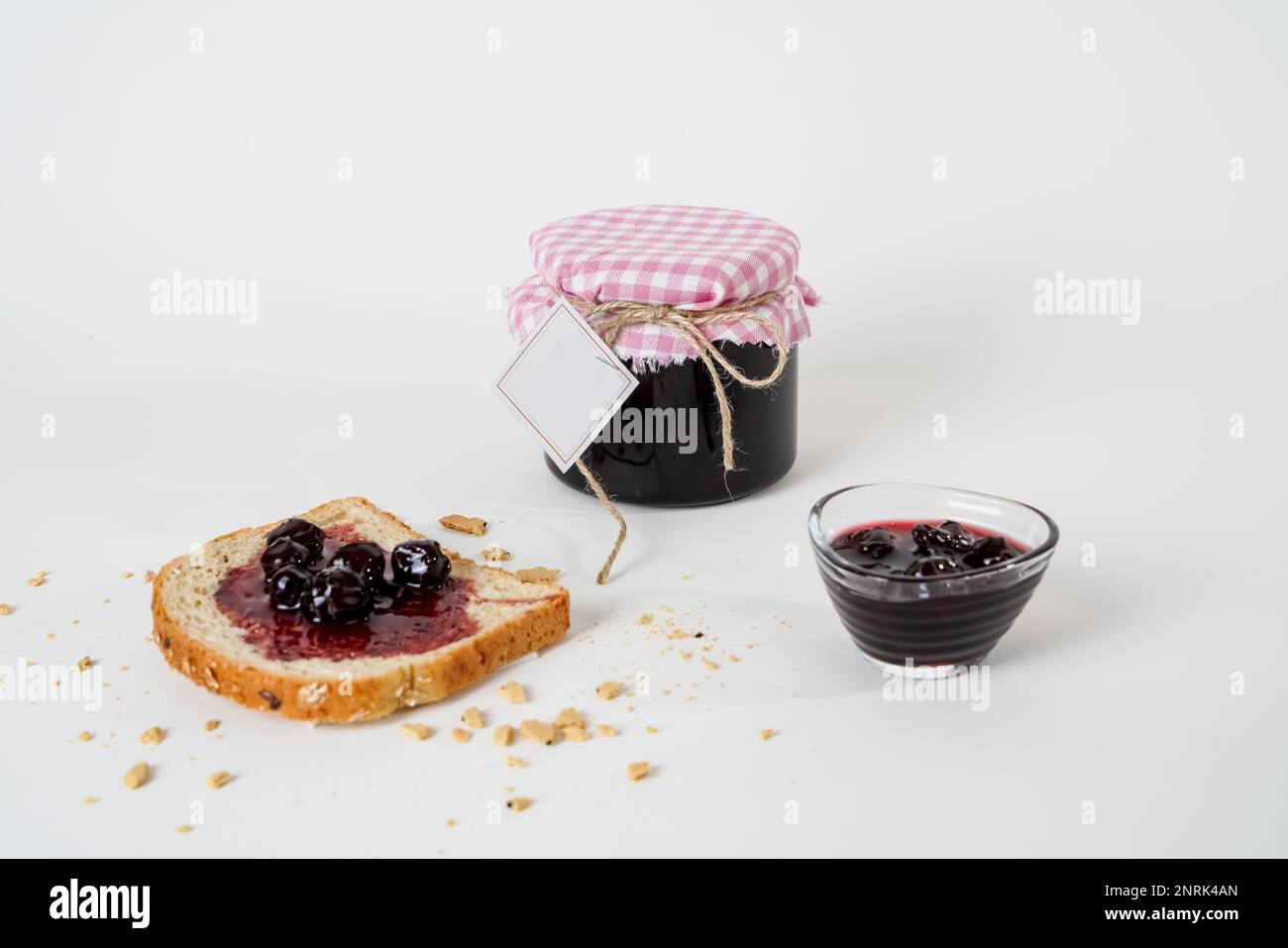 Traditional sour cherry jam jar with empty label, small bowl and a ...