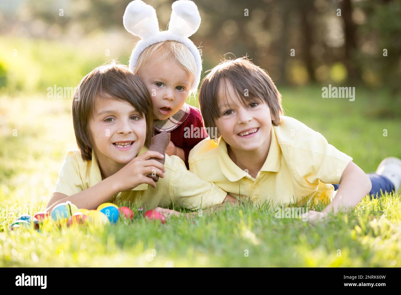 Sweet children, boy brothers with bunny ears, egg hunting for Easter ...