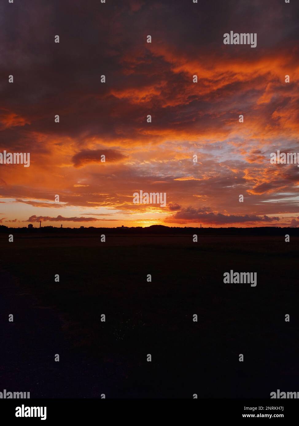 A vivid orange sunrise with a beautiful hue, with some wispy clouds and ...