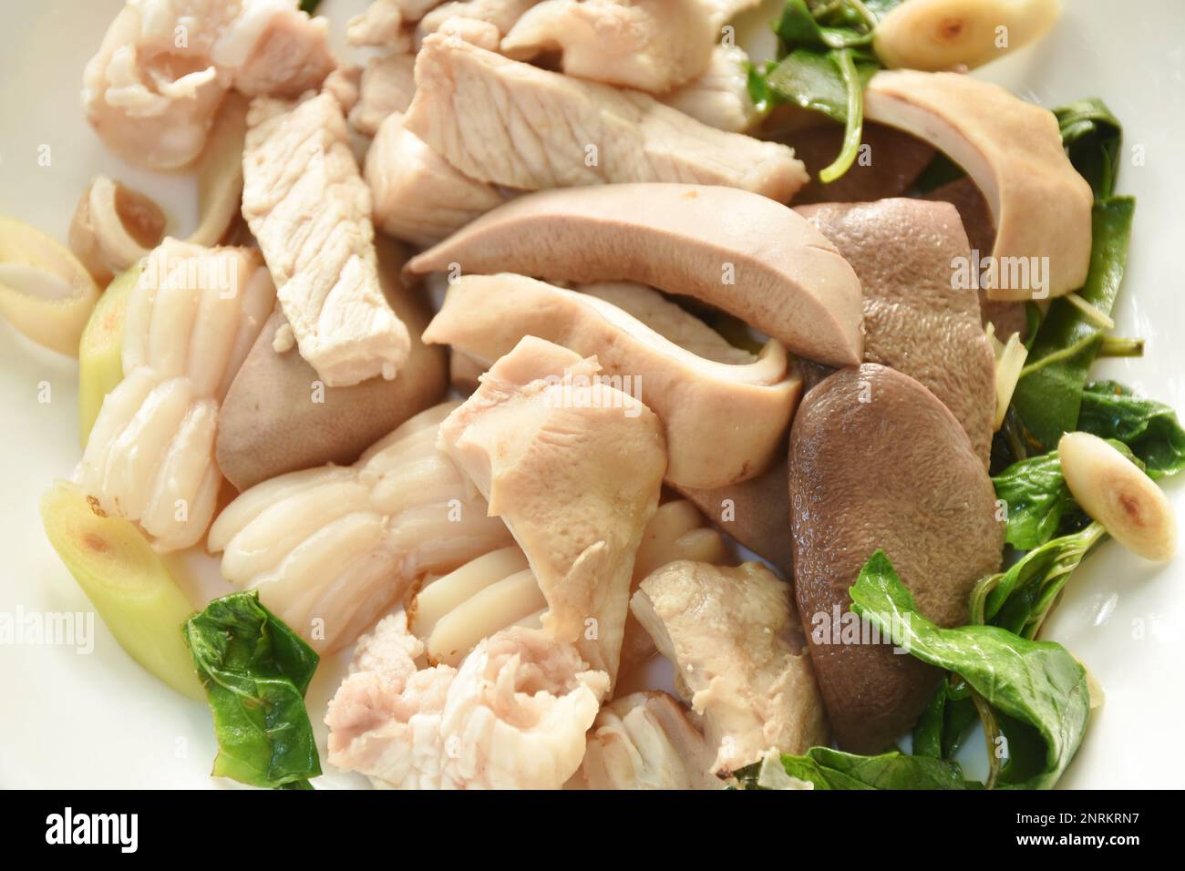 boiled slice pork meat and organ on plate dipping spicy and sour chili ...