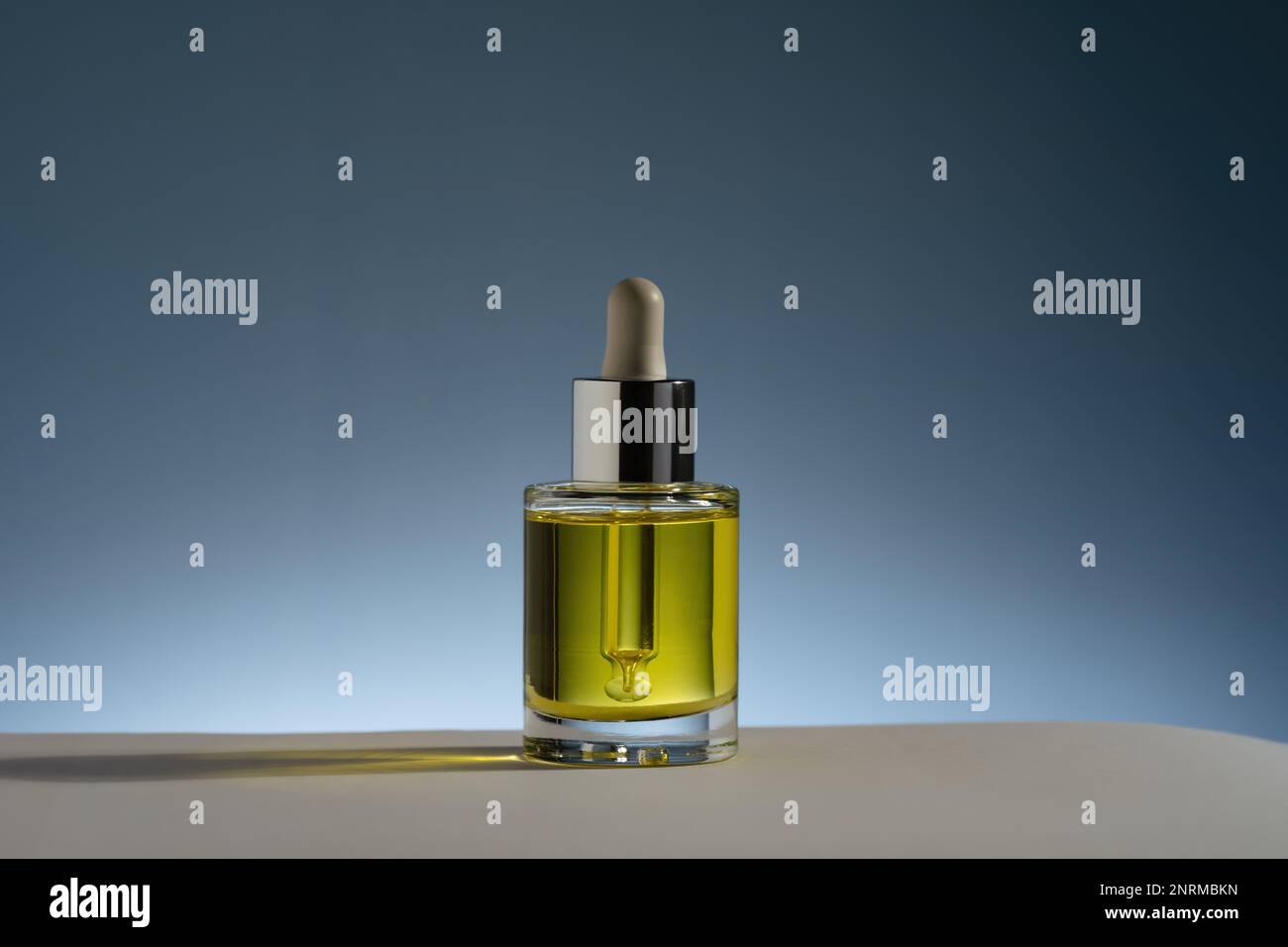 yellow face and hair oil in glass bottle with dropper pipette and white ...