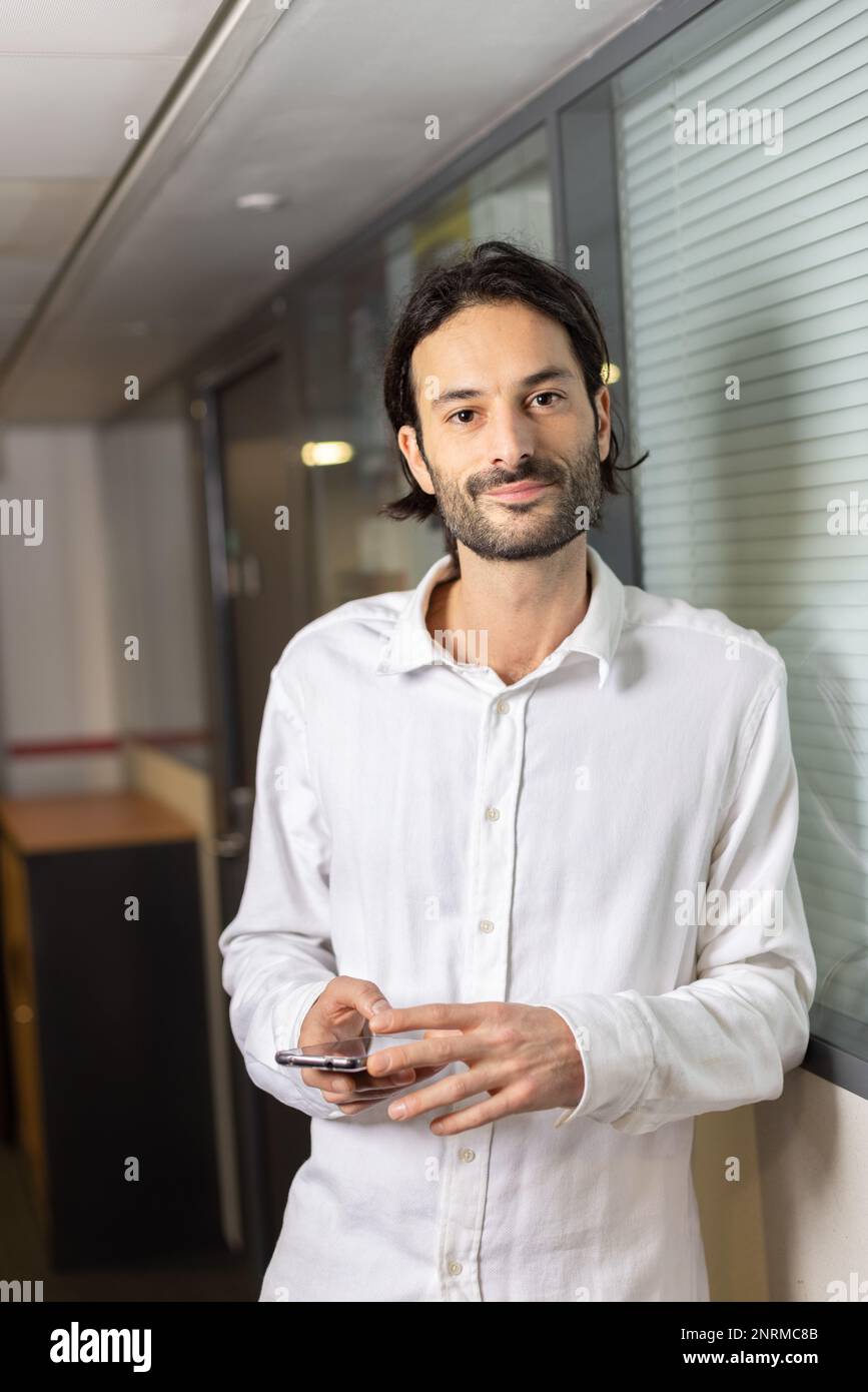 Portrait of a handsome 30-year-old man standing with his arms crossed ...