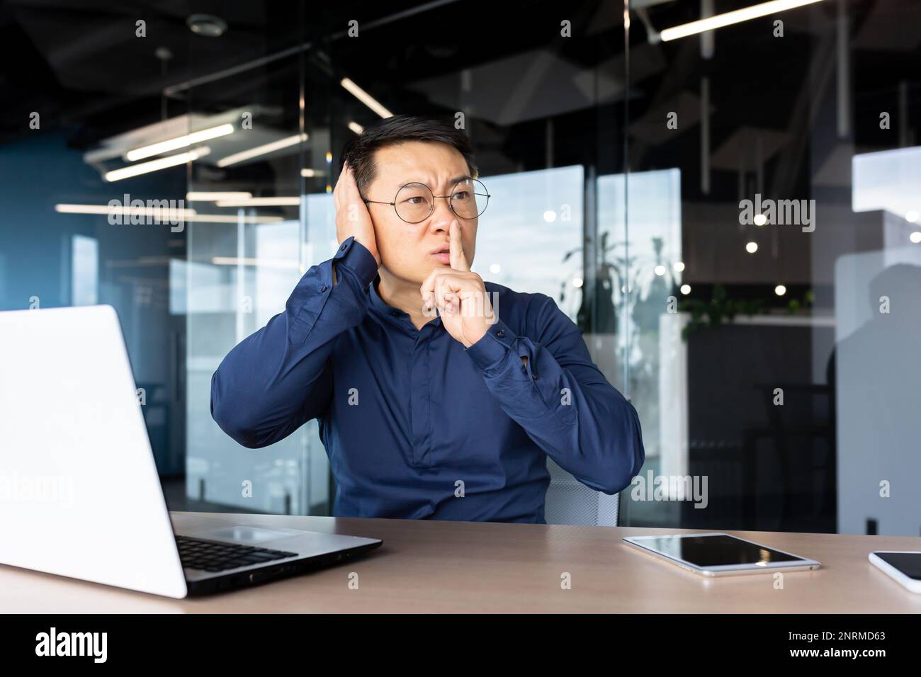 Upset and nervous asian man at workplace demanding silence from ...