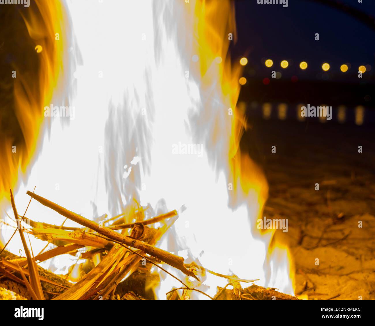 Bright flames of campfire fire for barbecue cooking at night behind ...