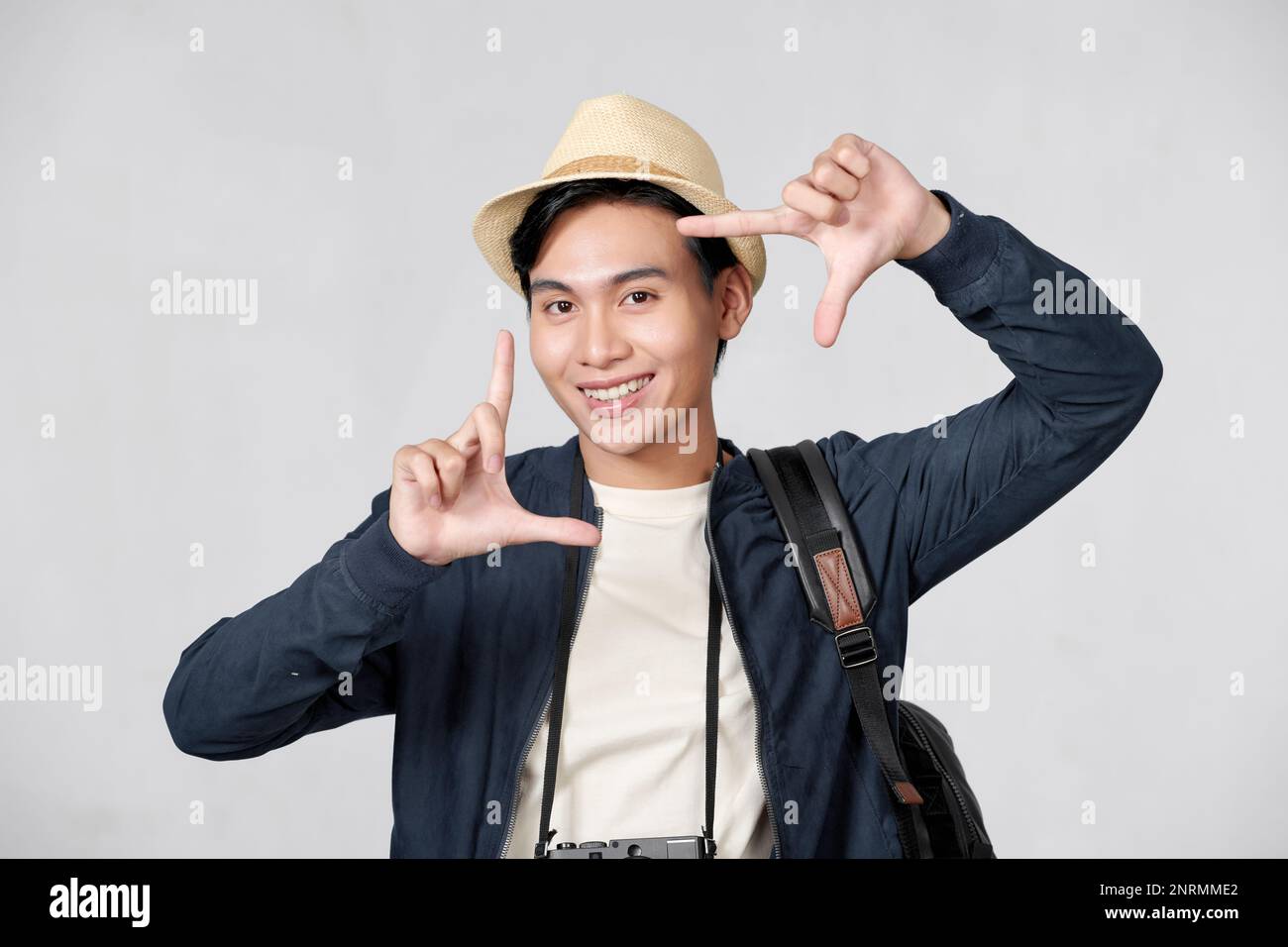 Handsome tourist young man smiling making frame with hands and fingers ...