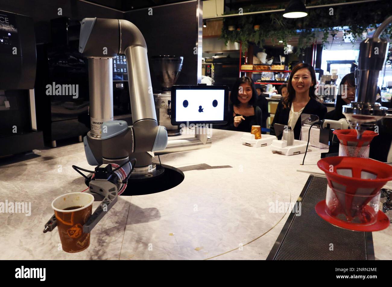 An arm-type robot which is equipped with AI communicates with customers ...