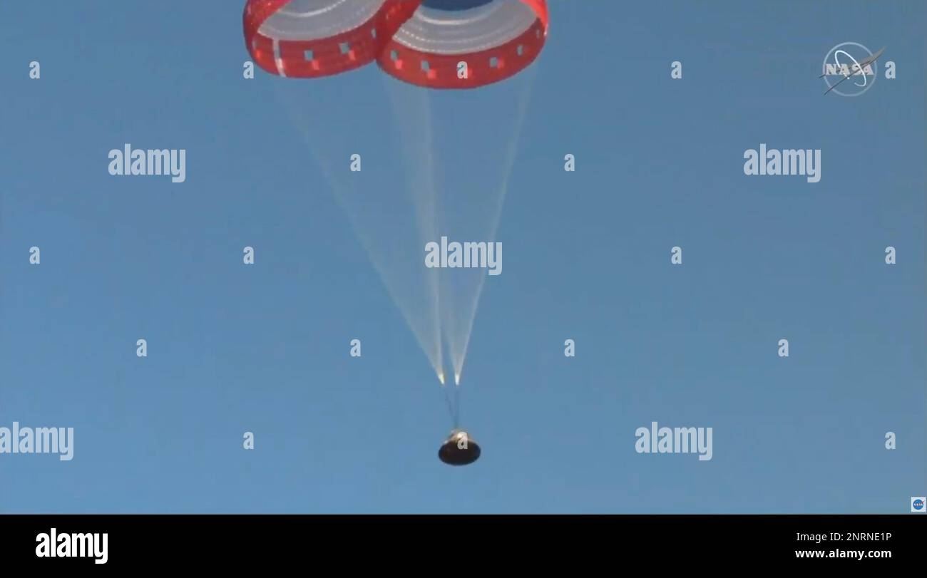 In this image made from a video provided by NASA parachutes guide the ...