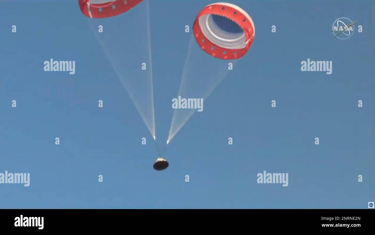 In this image made from a video provided by NASA parachutes guide the ...