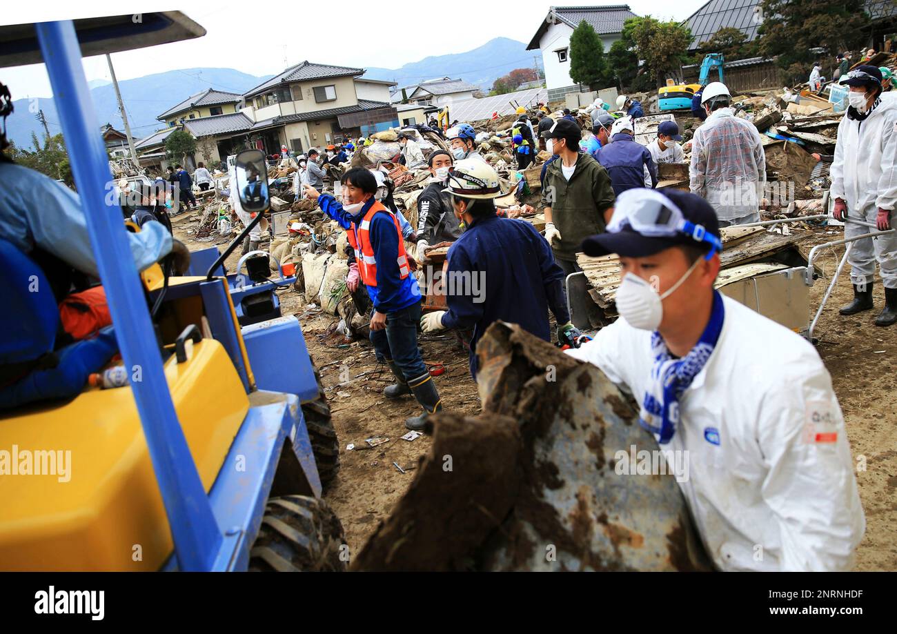 Volunteers work on cleaning up garbage and removing mud in Nagano City ...