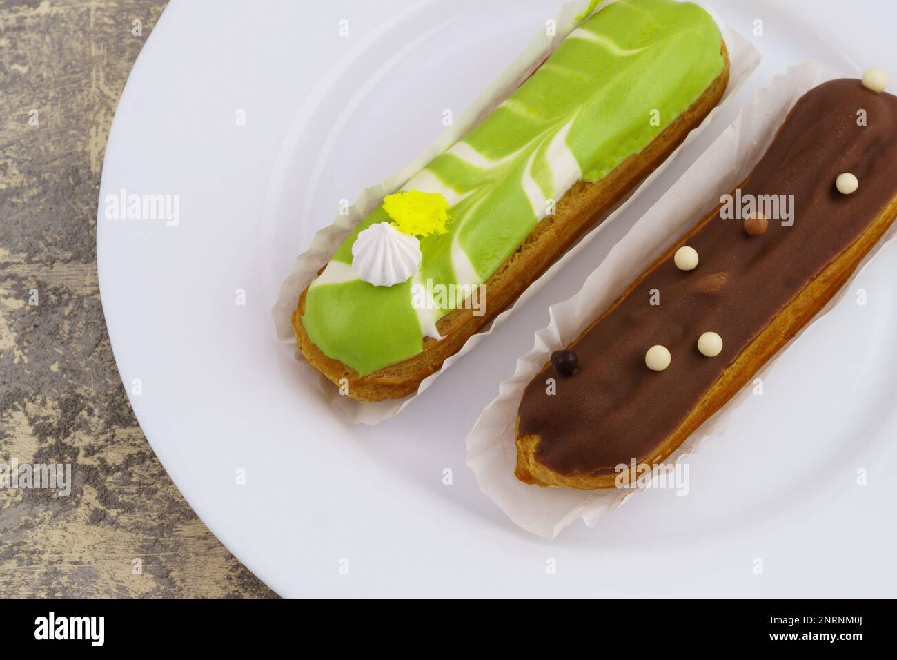 White plate with delicious green and brown glazed french dessert ...