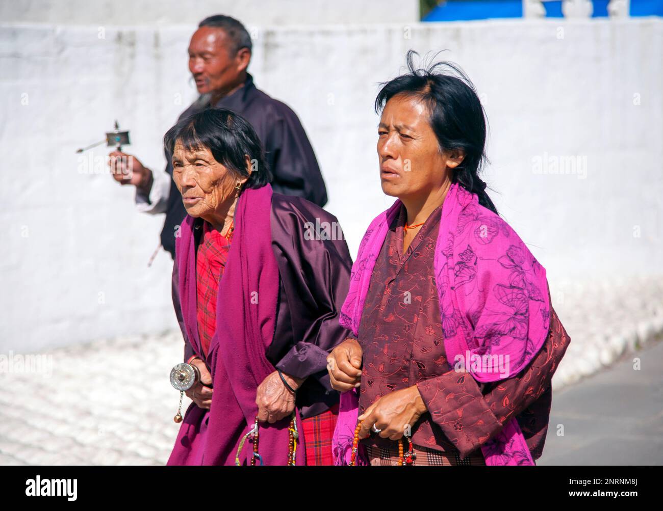 Pilgrim walking with prayer wheel in the city of Thimphu. Capital city ...