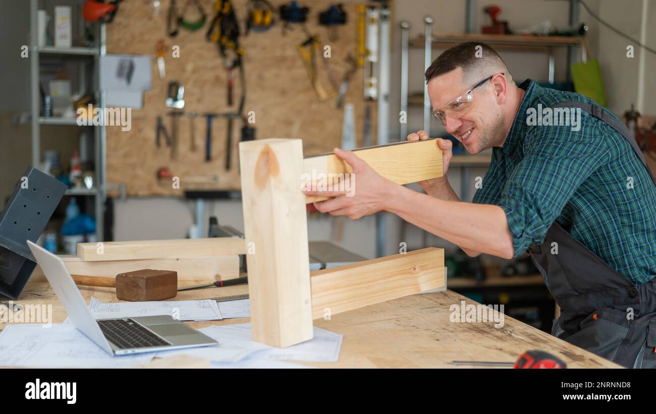 Carpenter measures wooden planks in the workshop Stock Photo - Alamy