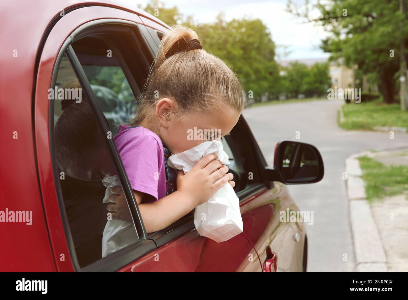 Little girl with paper bag suffering from nausea in car Stock Photo - Alamy