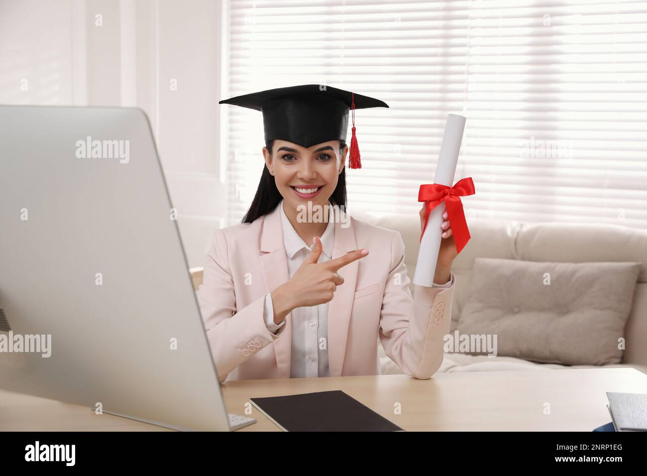 Happy student with graduation hat and diploma at workplace in office ...