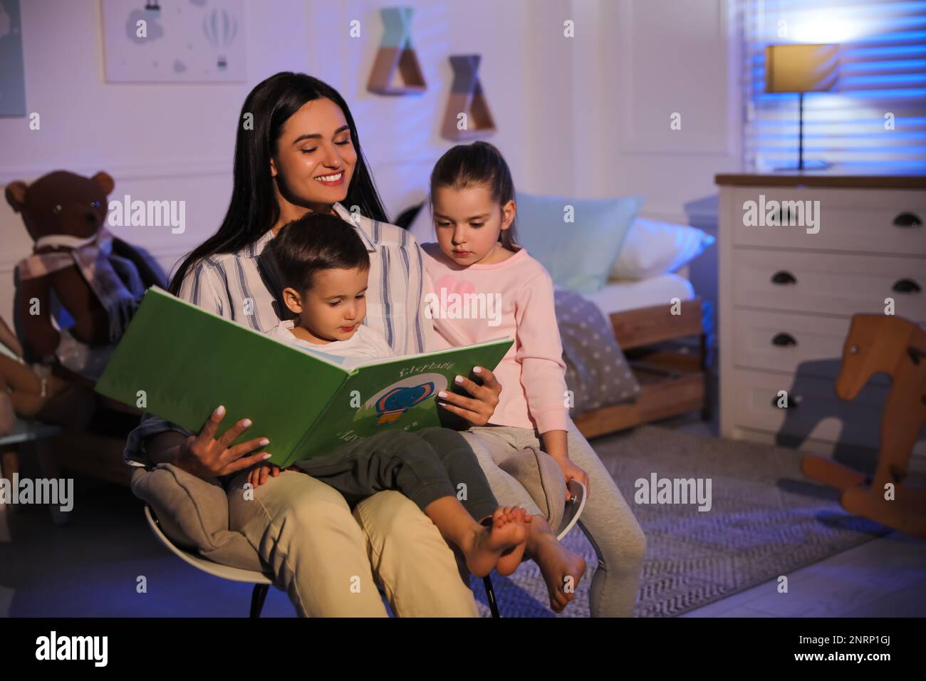 Mother reading bedtime story to her children at home Stock Photo - Alamy
