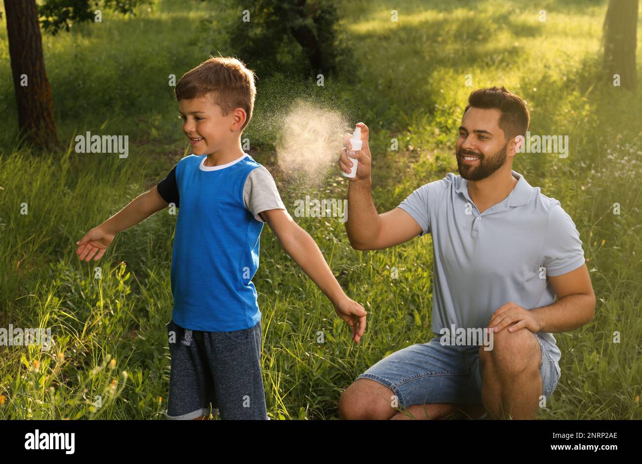 Man applying insect repellent on his son in park. Tick bites prevention ...