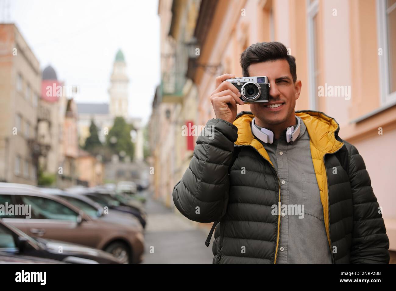 Tourist with camera taking photos on city street Stock Photo - Alamy