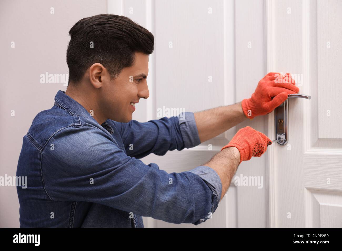Happy handyman fixing door hi-res stock photography and images - Alamy