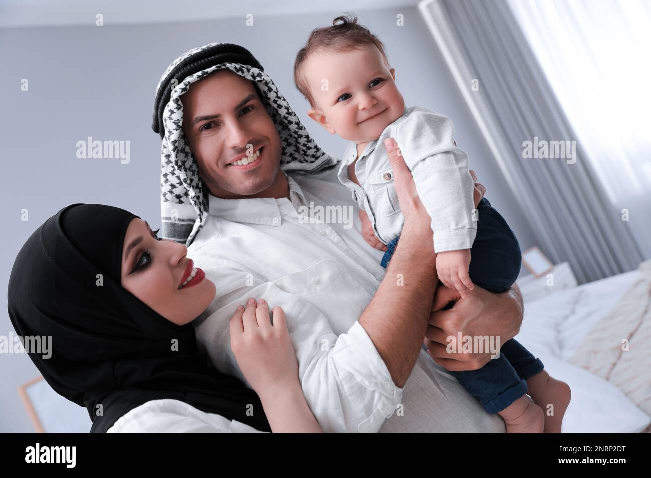 Happy Muslim family with little son in bedroom Stock Photo - Alamy