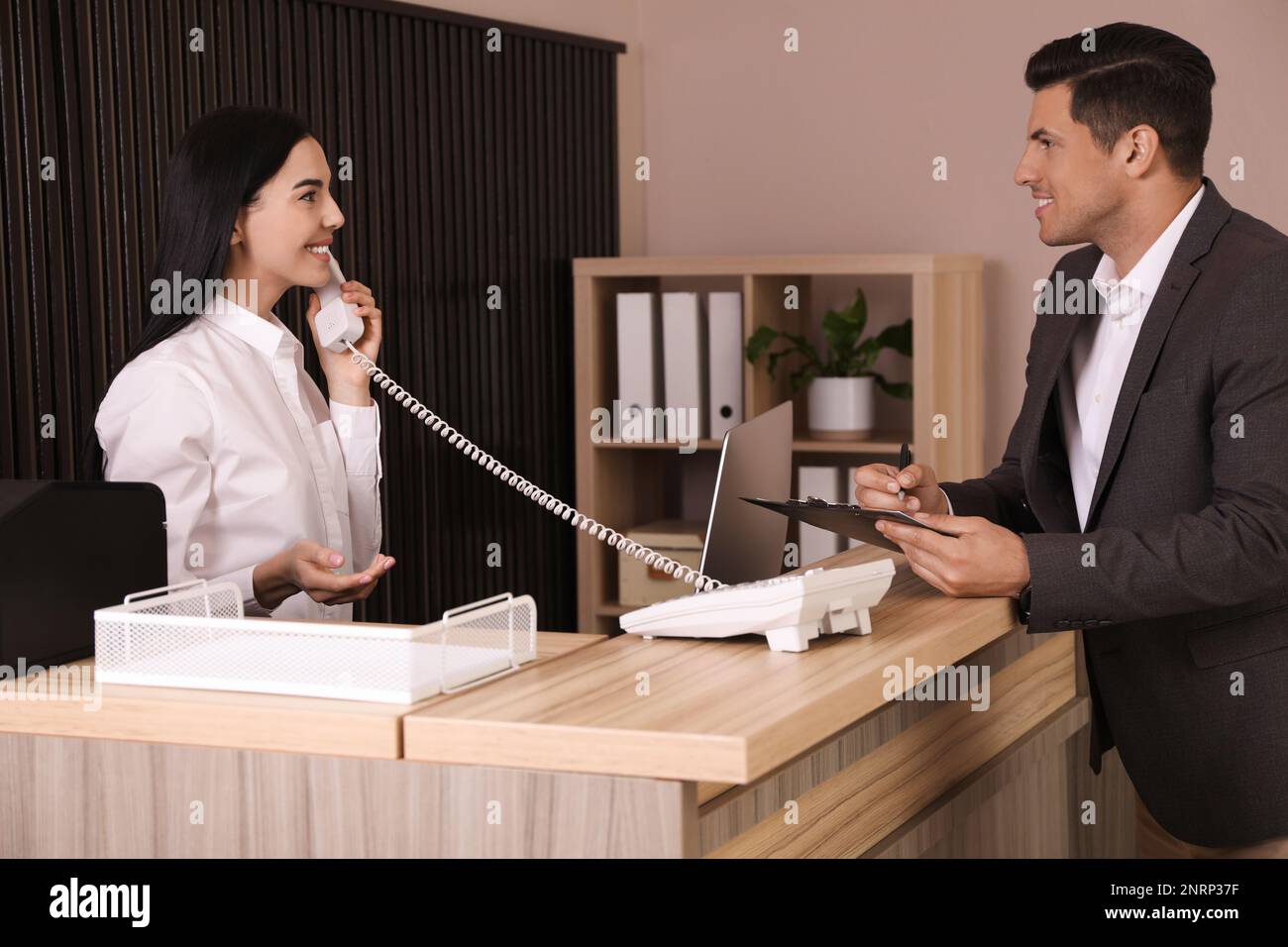 Male receptionist on the phone hi-res stock photography and images - Alamy