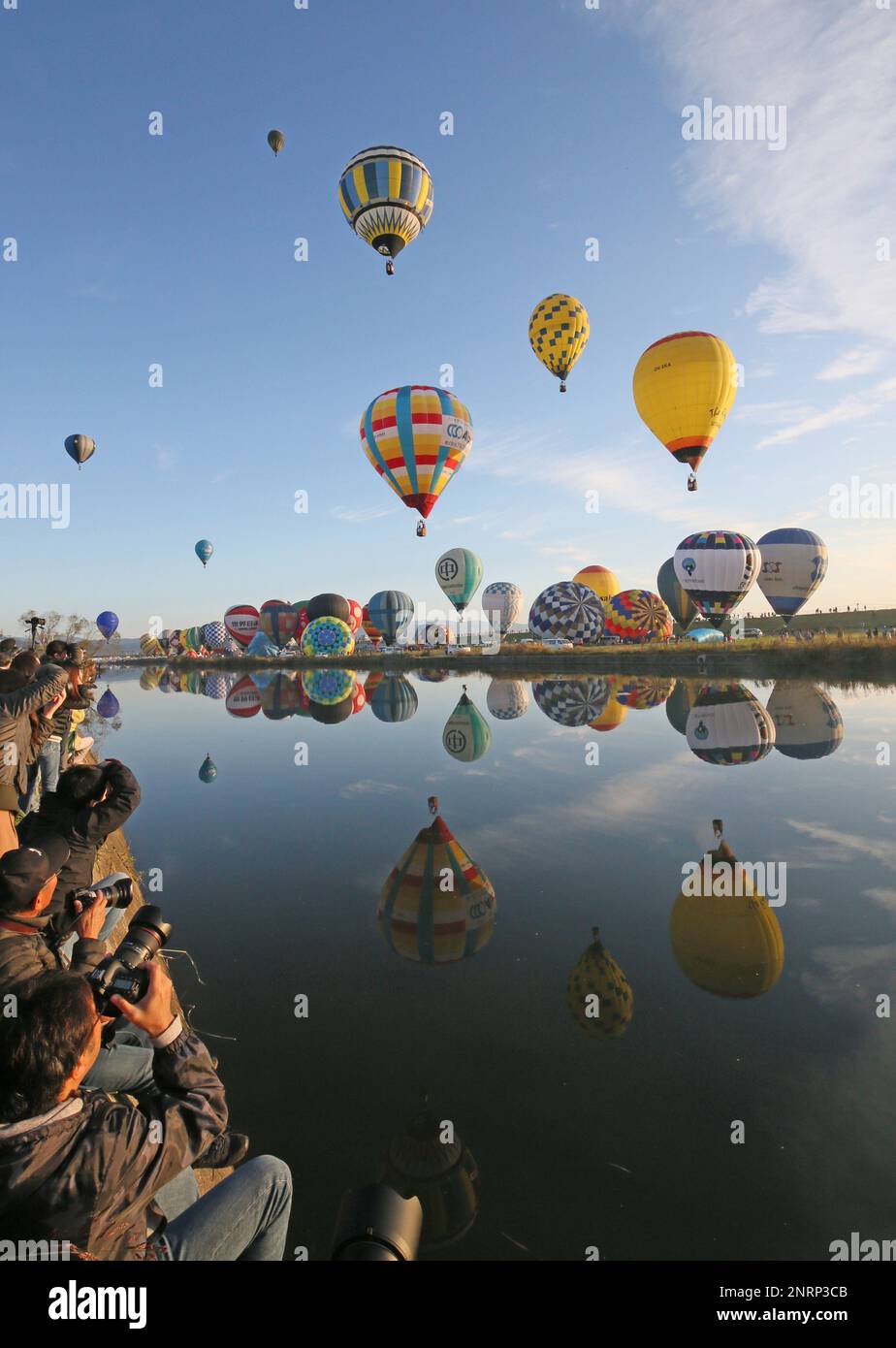 Colorful hot air balloons are hoisted along the Kasegawa river on the opening day of th Saga ...