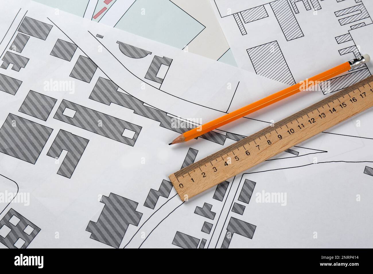 Pencil and ruler on cadastral maps of territory with buildings, flat ...
