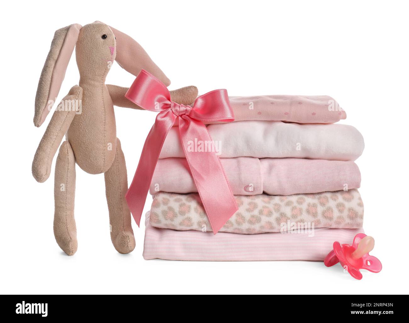 Stack of baby girl's clothes, pacifier and toy bunny on white ...