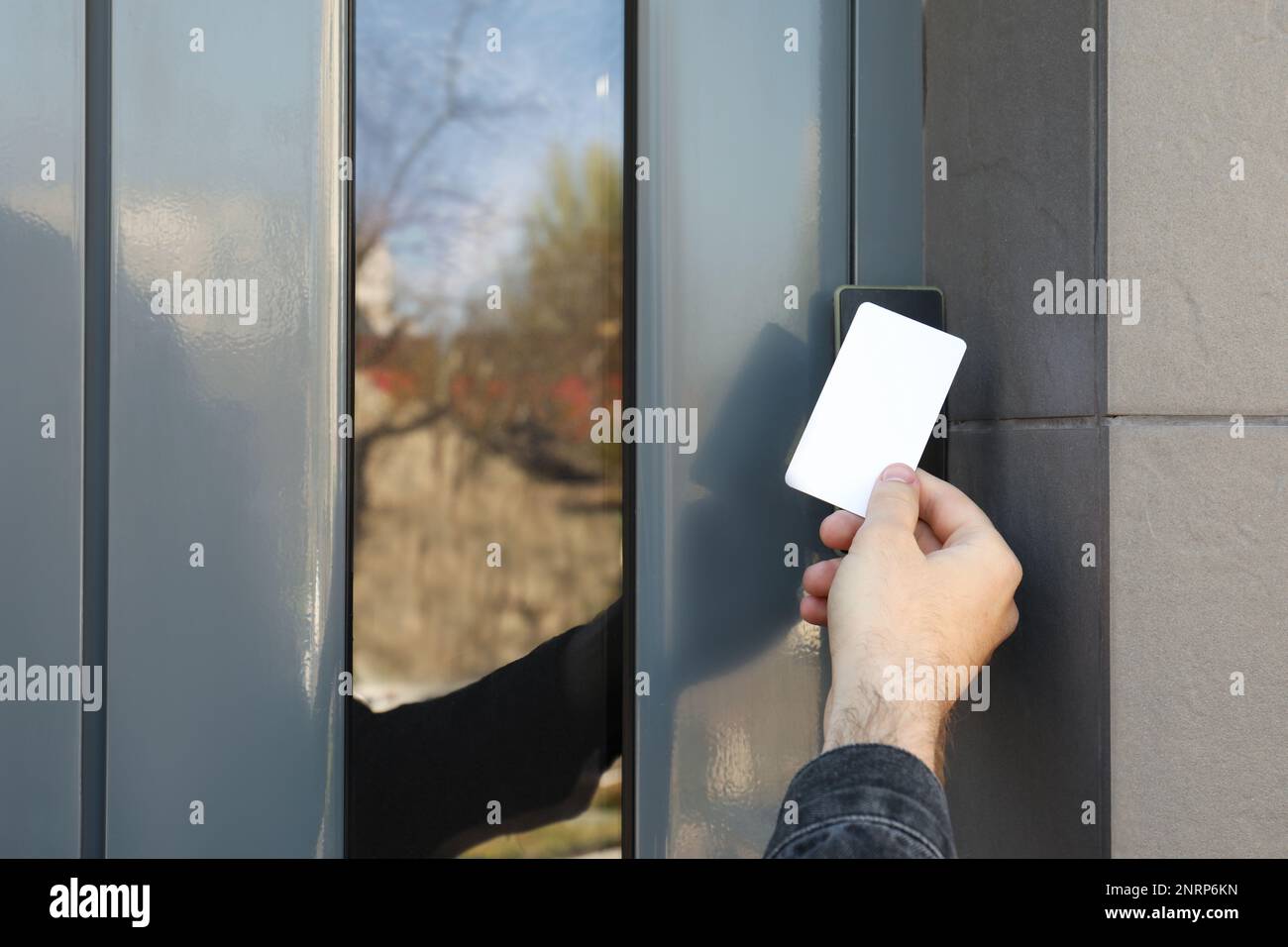 Man opening magnetic door lock with key card outdoors, closeup Stock ...