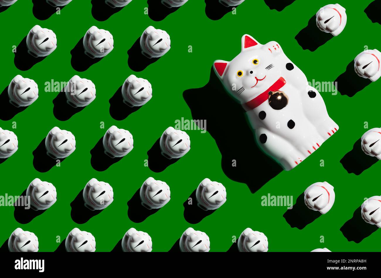 Pattern of maneki-neko cats on a green background. Beckoning cat. The ...