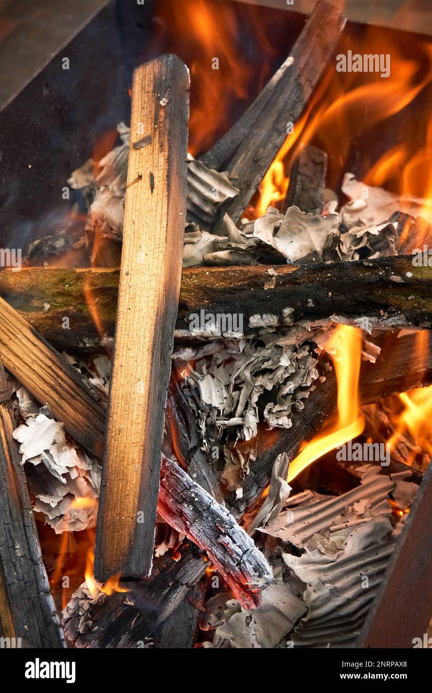 Wooden sticks and ashes from burnt paper engulfed in fire, burning ...