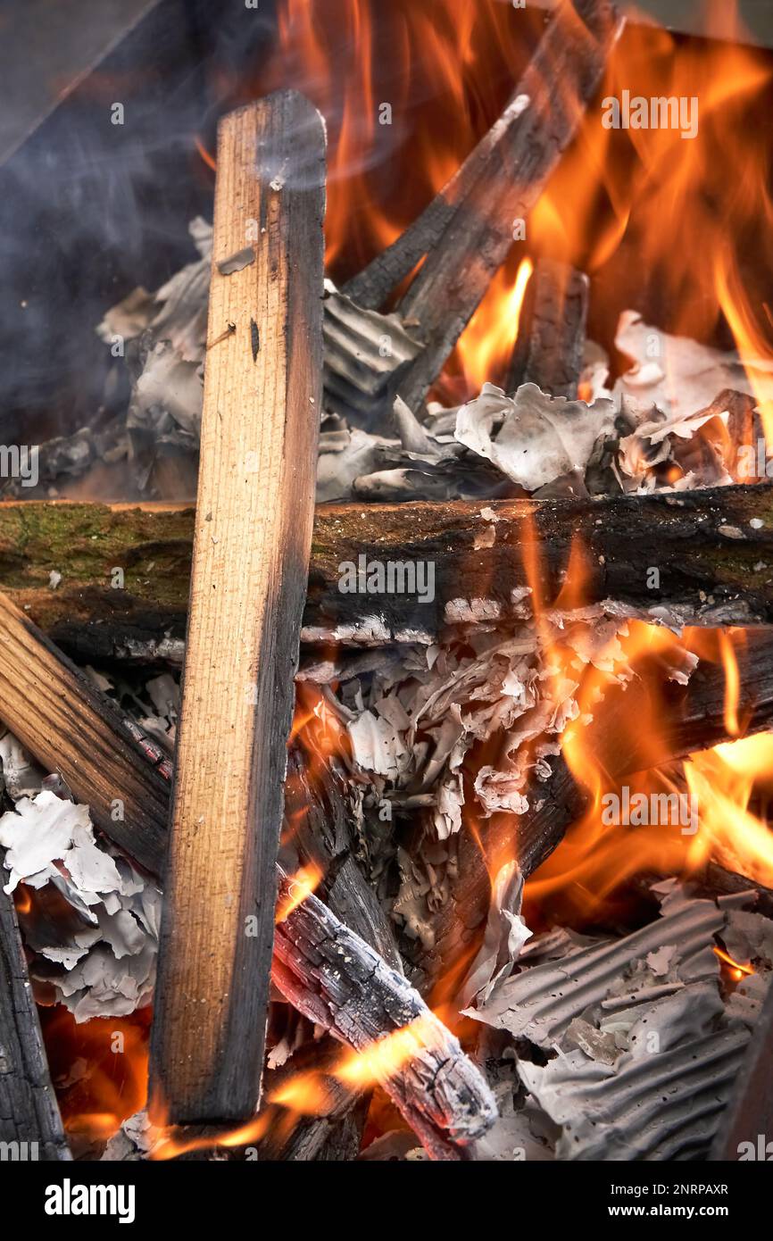 Wooden sticks and ashes from burnt paper engulfed in fire, burning ...