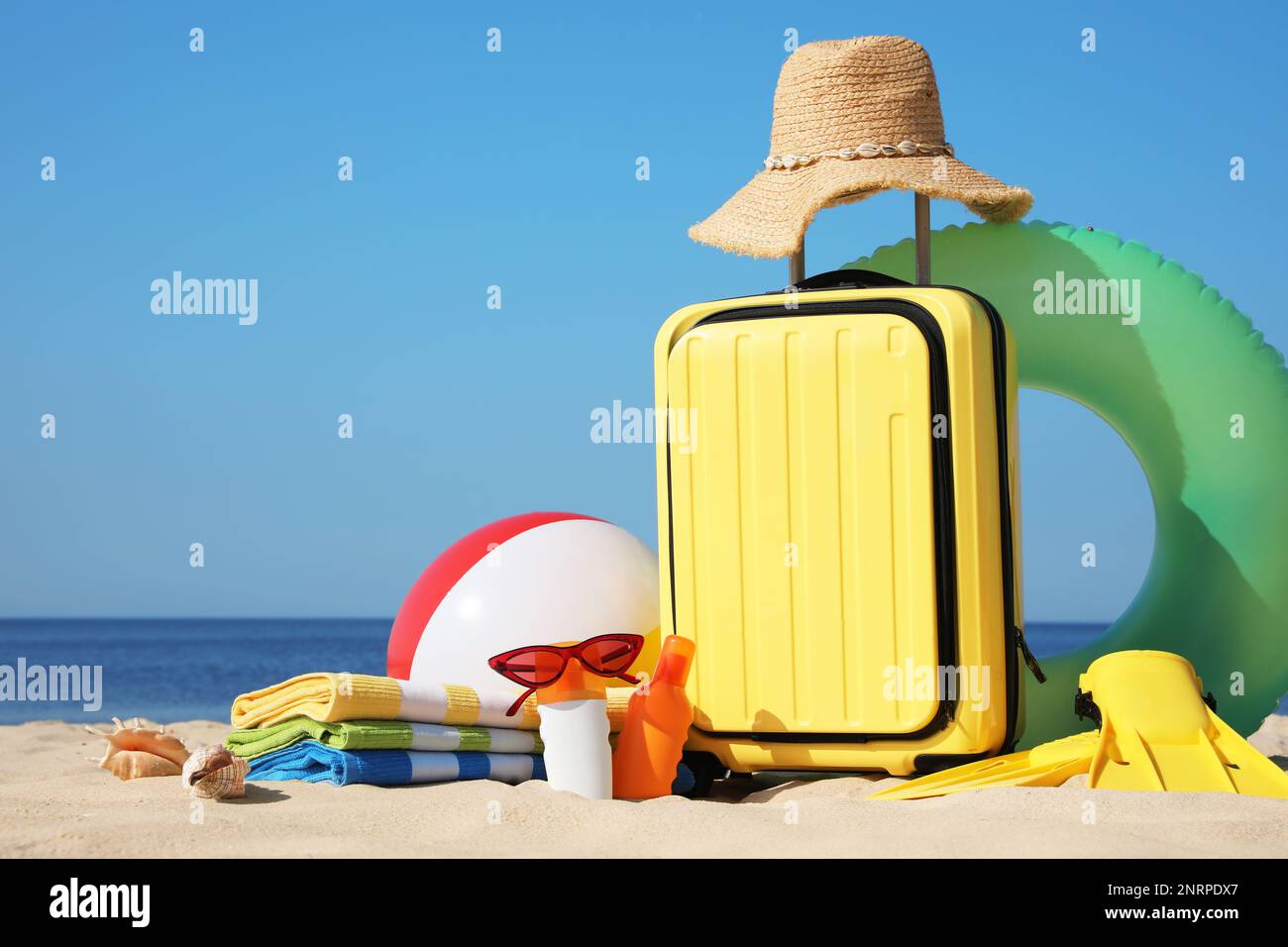 Suitcase and stylish beach accessories on seaside Stock Photo - Alamy