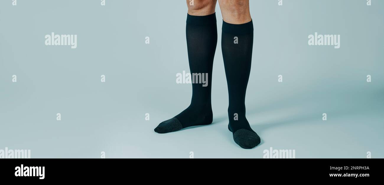 closeup of a man, standing on an off-white background, wearing ...