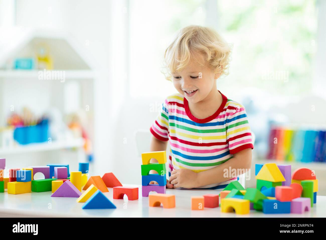 Kid playing with colorful toy blocks. Little boy building tower of ...
