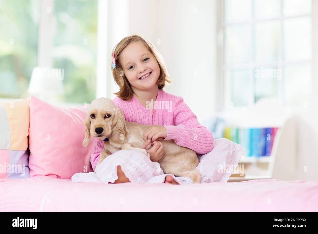 Child playing with baby dog. Kids play with puppy. Little girl and ...