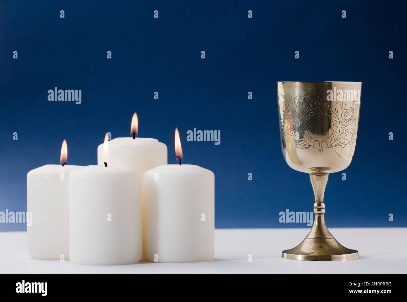 beautiful christian chalice surrounded by candles and blue background ...
