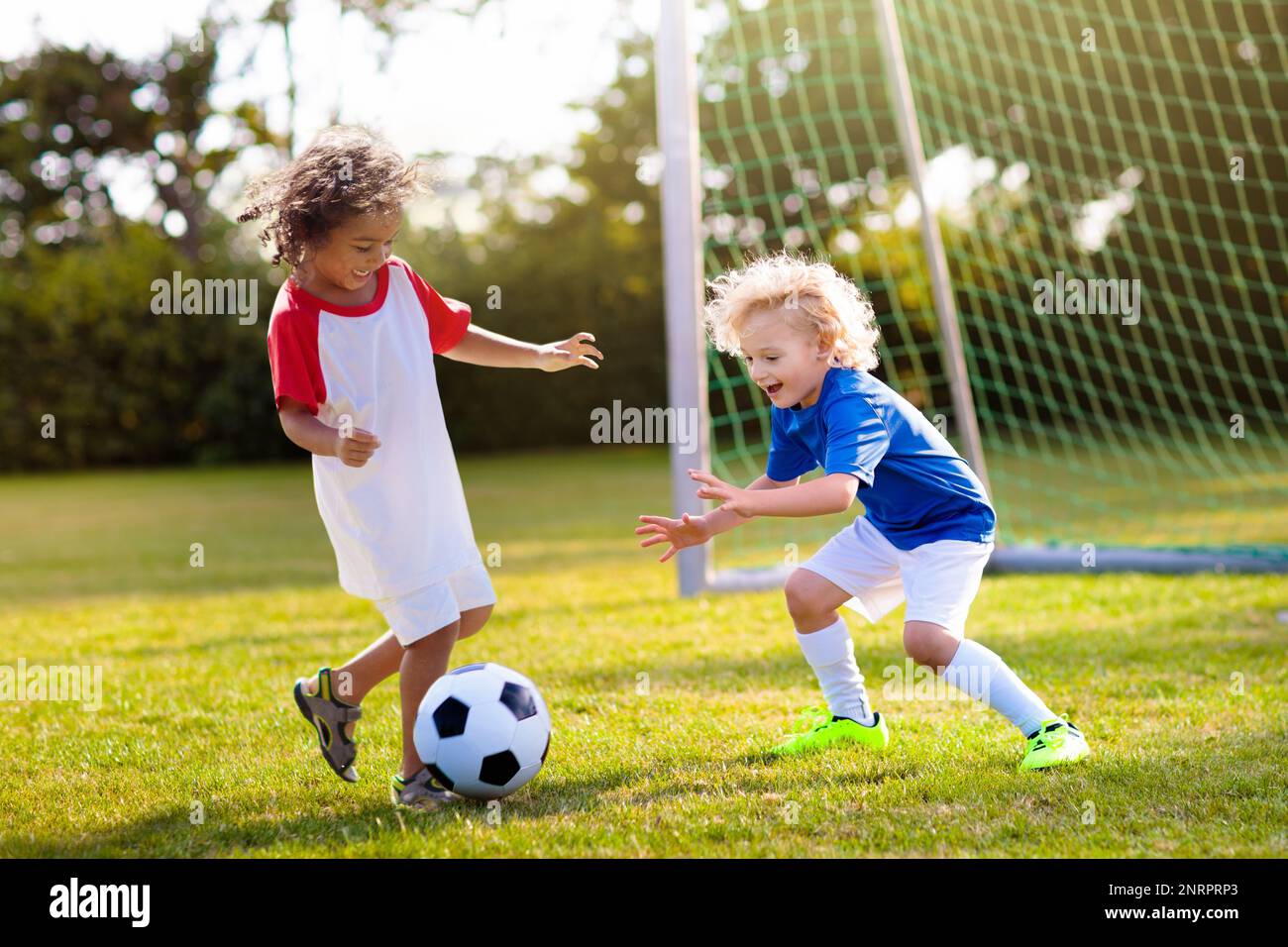 Kids play football. Cute little boy playing football. Children run on ...