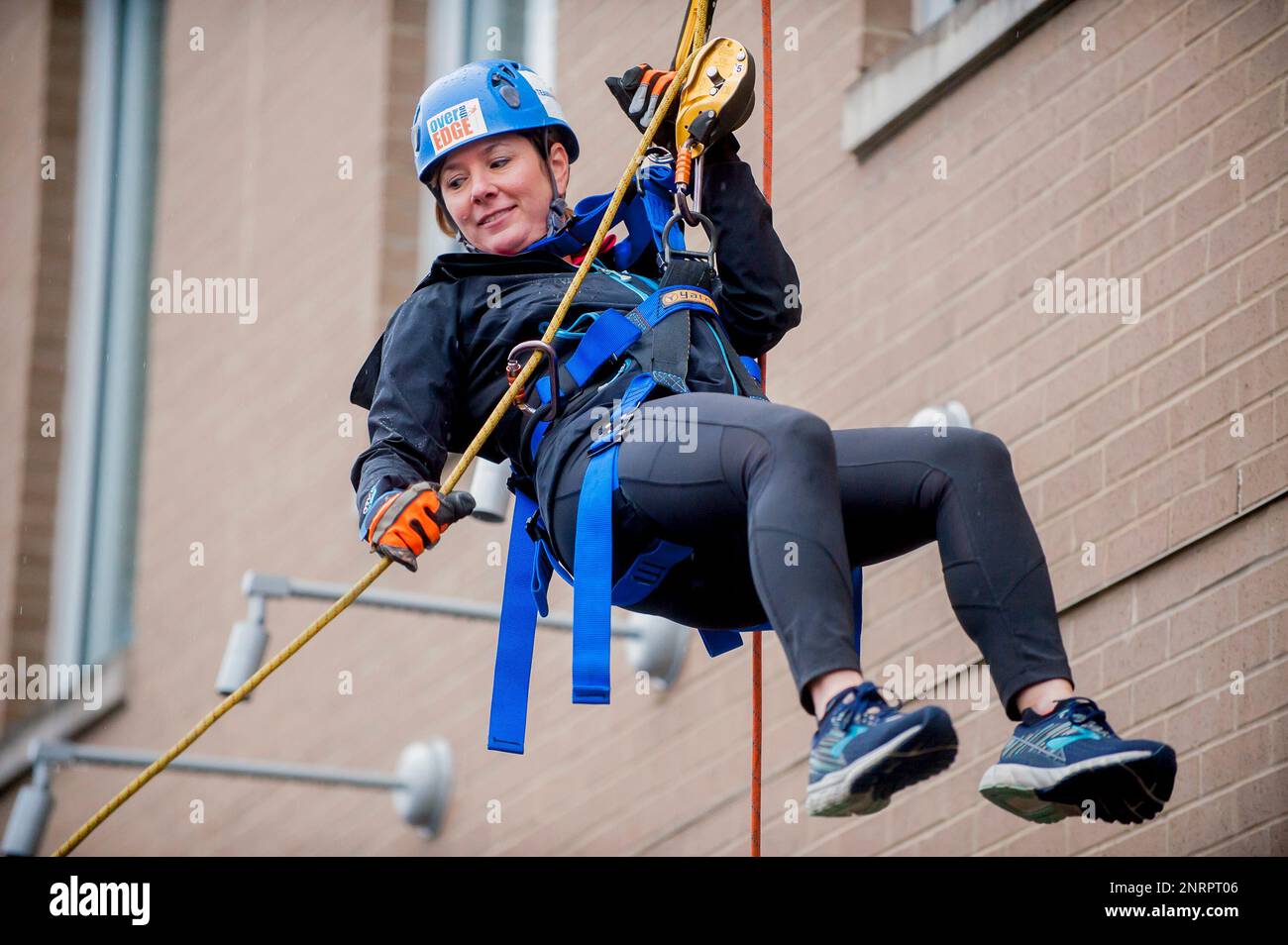 Nat's Outdoor Sports owner Lisa Martens rappels down a building wall ...