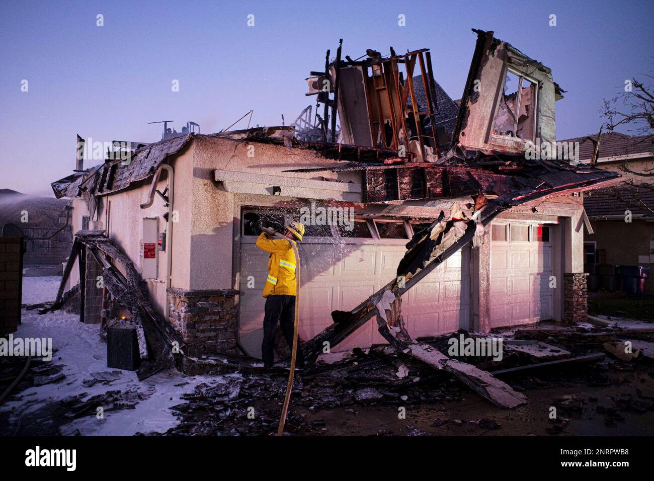 Firefighters put out hot spots on a house burned in the Tick fire on ...