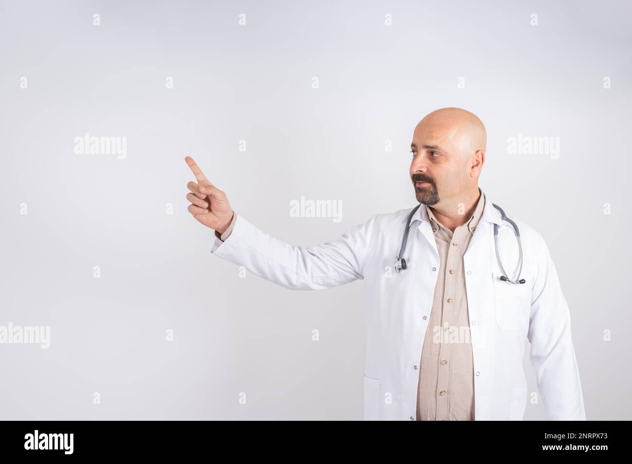 Smiling doctor showing copy space. Caucasian handsome male doctor in ...