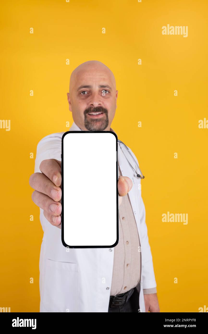 portrait of male doctor showing empty white screen of smartphone ...
