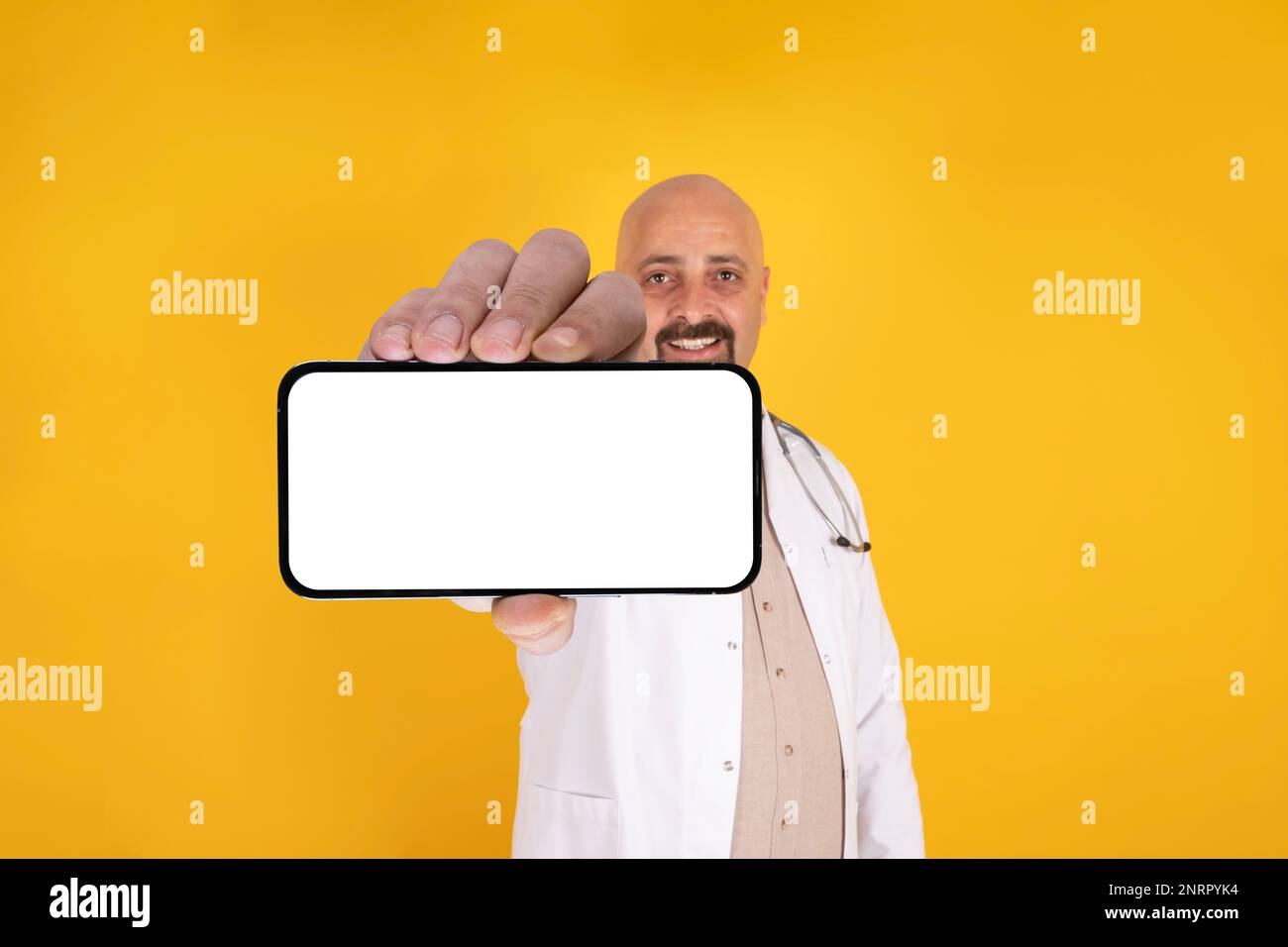 Caucasian doctor showing horizontal phone mock up. Empty blank white ...