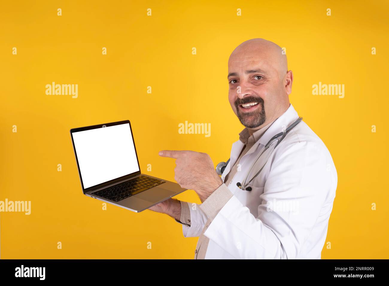Doctor showing empty white screen of modern laptop for mock up. Online ...