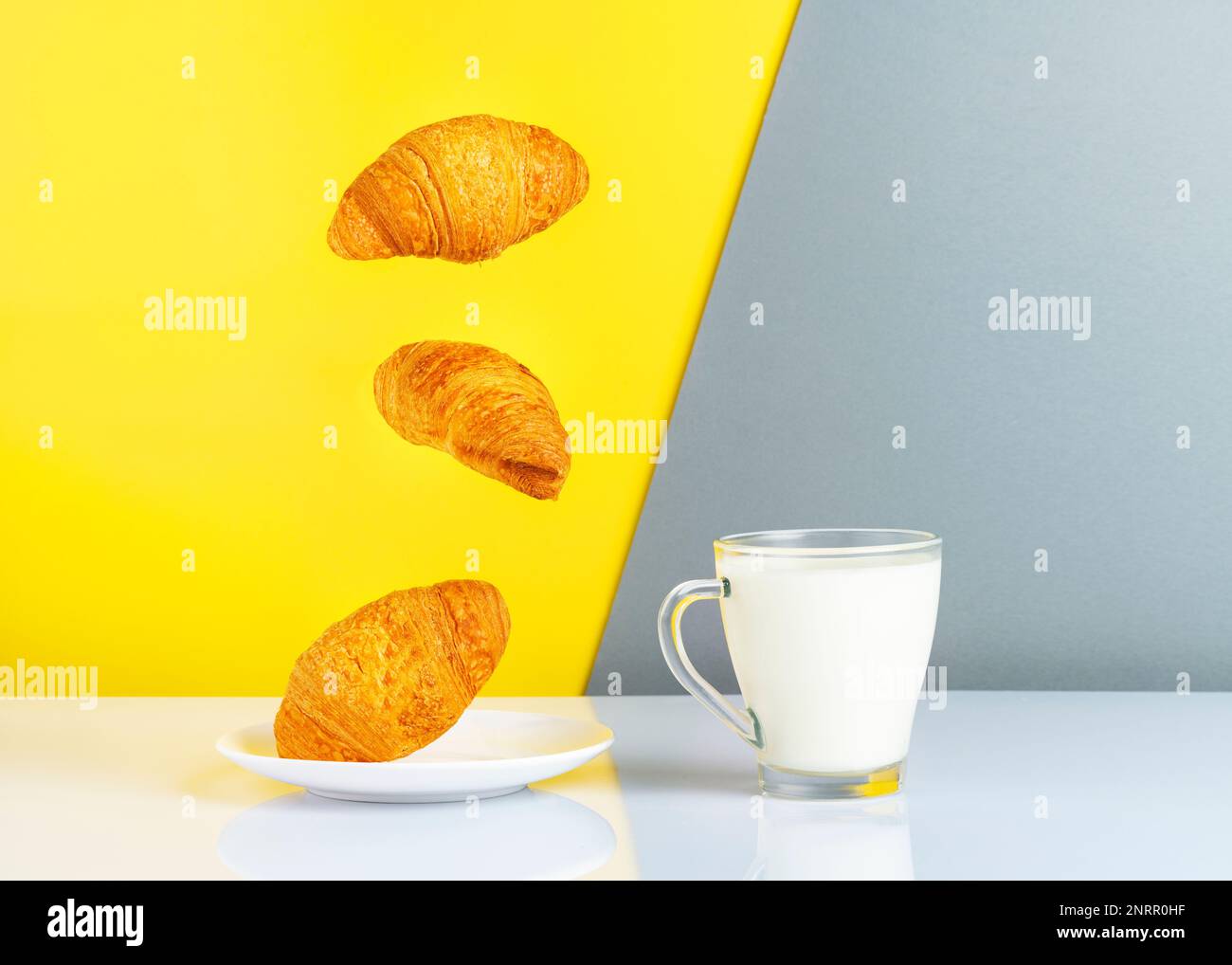 breakfast concept cup of milk and flying croissants Stock Photo - Alamy