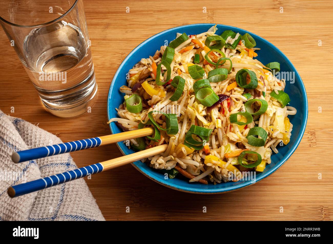 Fried rice with vegetables in a blue bowl with chopsticks, vegan asian ...