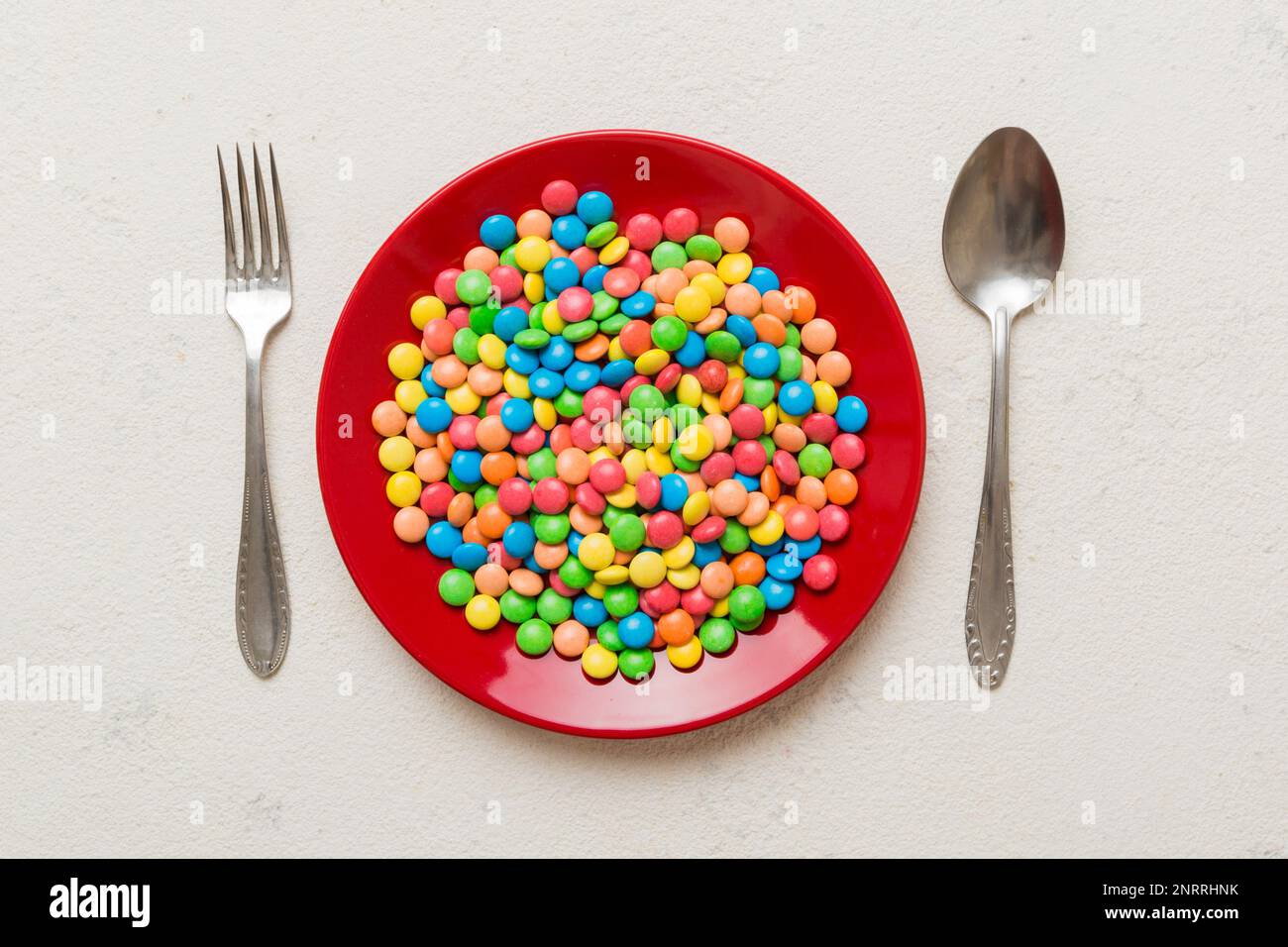 cutlery on table and sweet plate of candy. Health and obesity concept ...