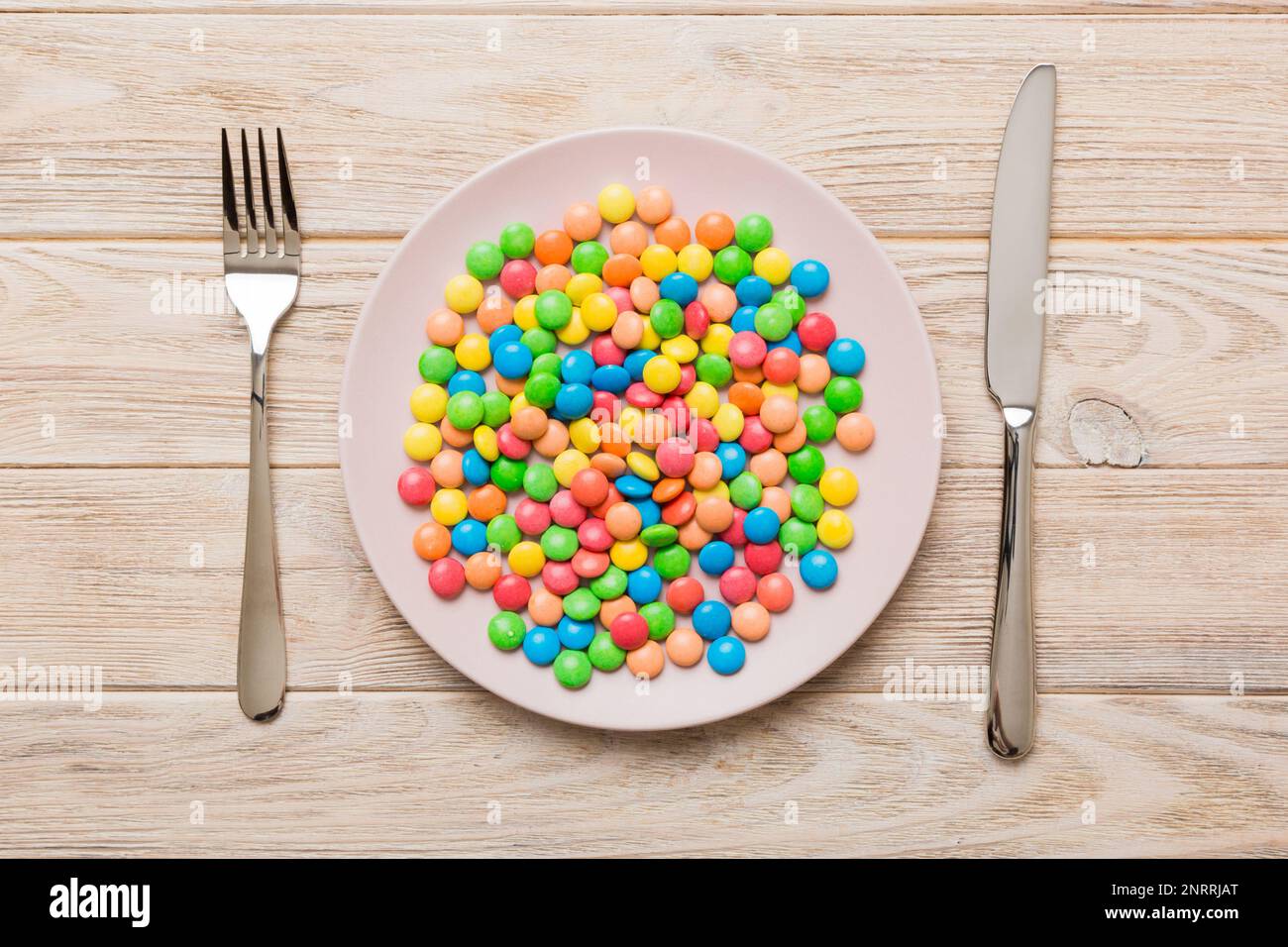 cutlery on table and sweet plate of candy. Health and obesity concept ...