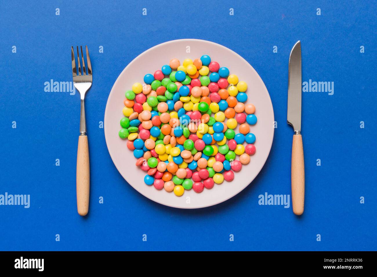 cutlery on table and sweet plate of candy. Health and obesity concept ...