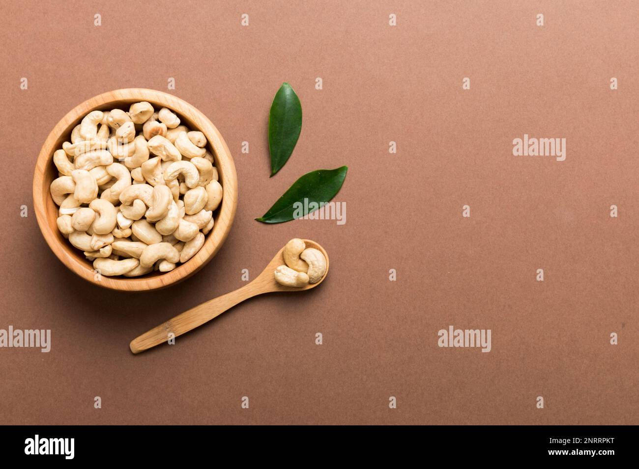 cashew nuts in wooden bowl on table background. top view. Space for ...