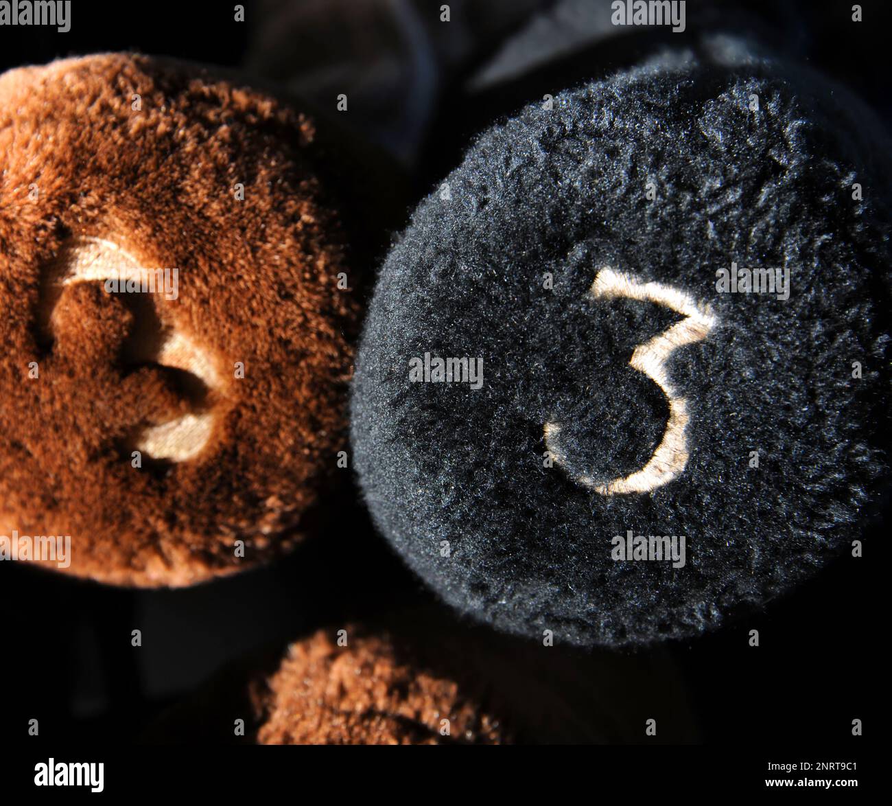 Three golf clubs are protected by black and brown fuzzy golf club ...